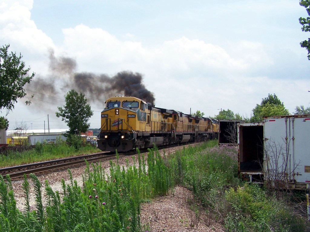 CNW 8646, pulling a long train, pours on the fuel to accelerate out of Butler yard on the west ...